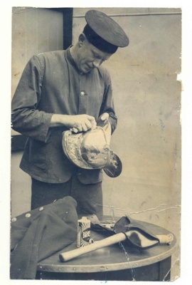 Photograph, Firefighter cleaning helmet; 1940; PH2007.001 | eHive