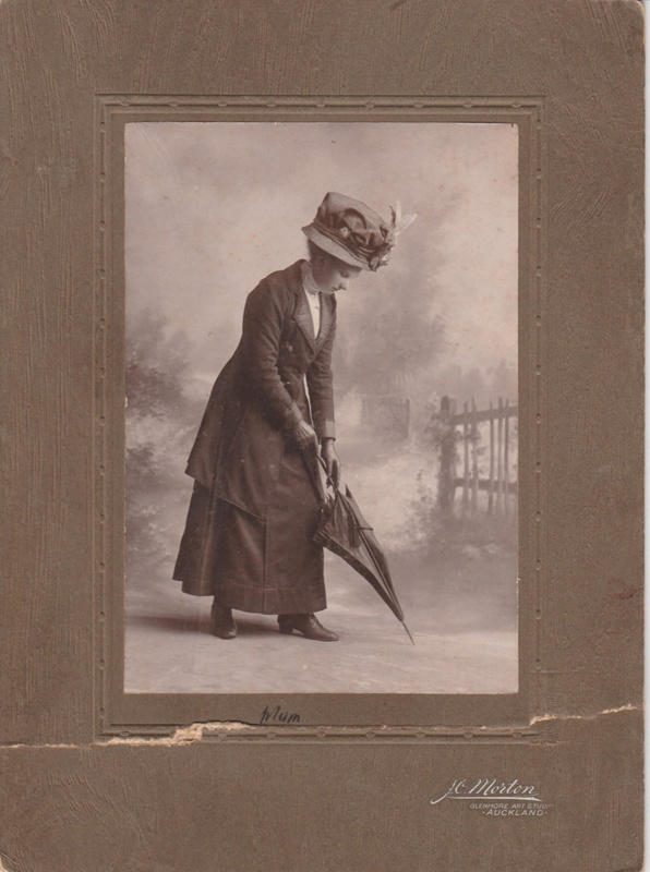 Mrs Amelia Wood (nee Yeates) bending over to open an umbrella.; Morton ...