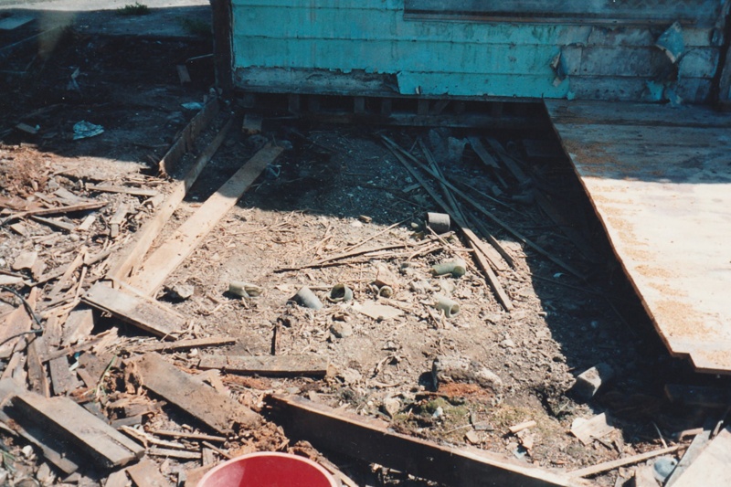 Foundation block of back of lean-to with sawdust on moss covered earth ...