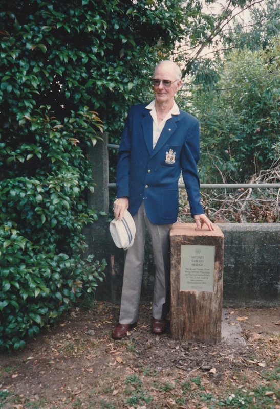 Sir Lloyd Elsmore standing beside the Tamaki River Bridge placque ...