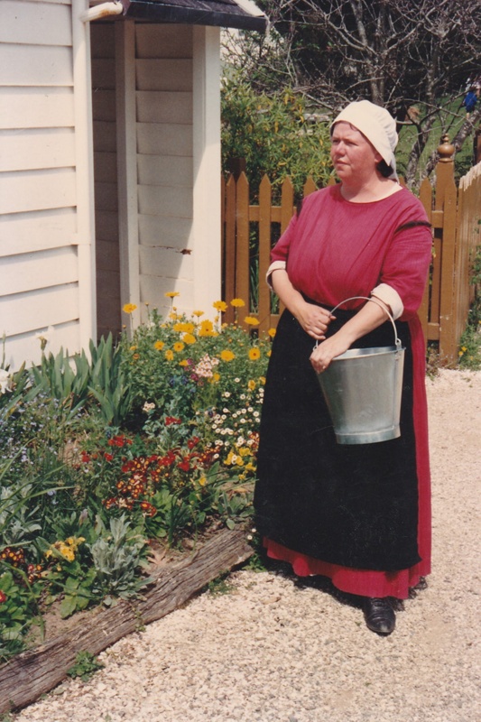 Debbie Benson in costume as Maggie Thompson in front of a cottage ...