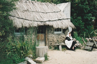 Marion Cartwright in costume sitting on the bench in front of the Sod ...
