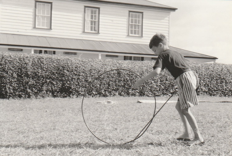 A boy rolling a hoop with an iron hoop and skimmer (stick) at Howick ...