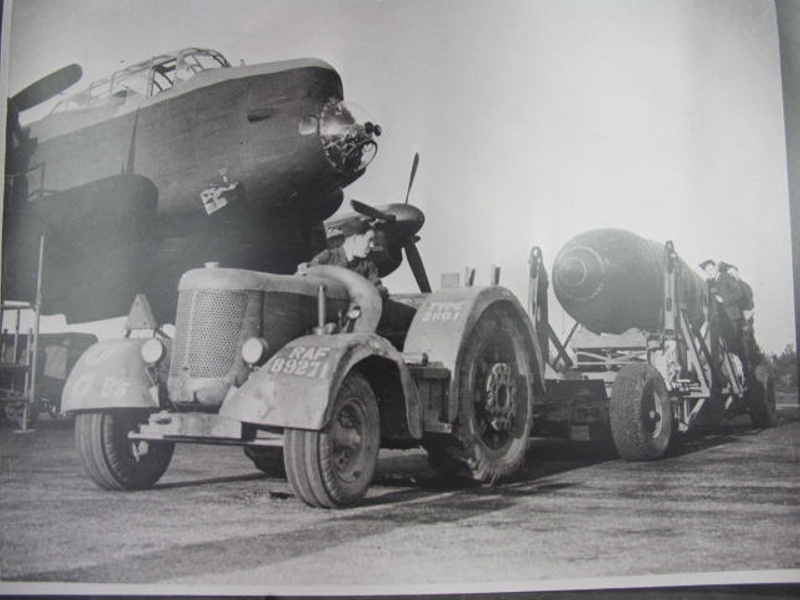 Photograph of RAF jeep towing weaponry with Lancaster bomber in the ...