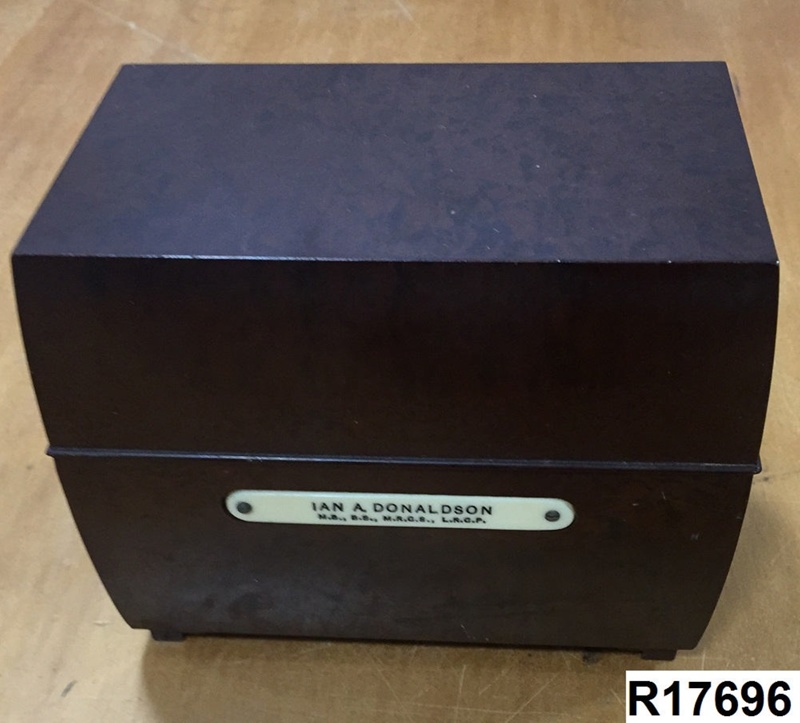 Bakelite box with attached lid and white plastic name sign.; R17696 | eHive