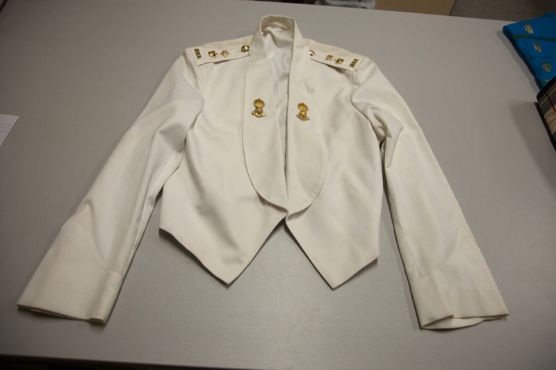 A fitted waist length white military mess jacket with epaulets and gold ...