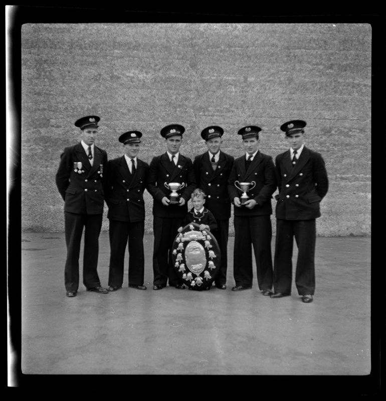 Six men and one small boy with shield and two cups, Fire Brigade April ...