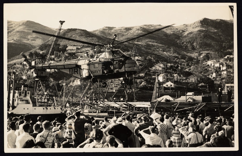 Crowd watching US Navy helicopter landing on helipad.; Unknown; 1900 ...