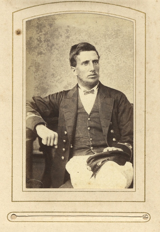 Studio photo of a seated young man posing in military attire.; J.Hubert ...