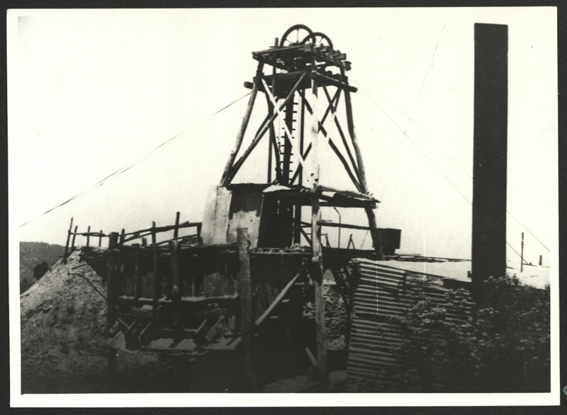 Photo of a poppet head alongside an engine shed and chimney; Unknown; c ...