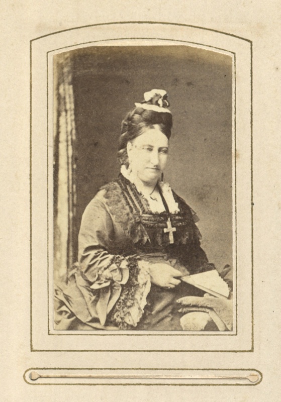 Studio photo of a seated lady in formal attire with plaited hair in a ...