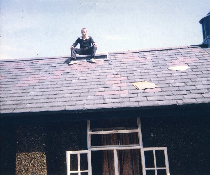 Photograph of Philip Askew, sitting on the roof of Blake 4 Mess at HMS ...