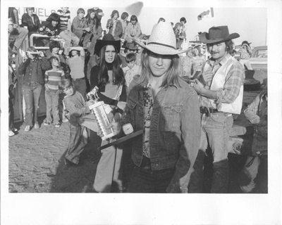 A young rider holds up her trophy at the rodeo in 1975; FNPL2018.008. ...